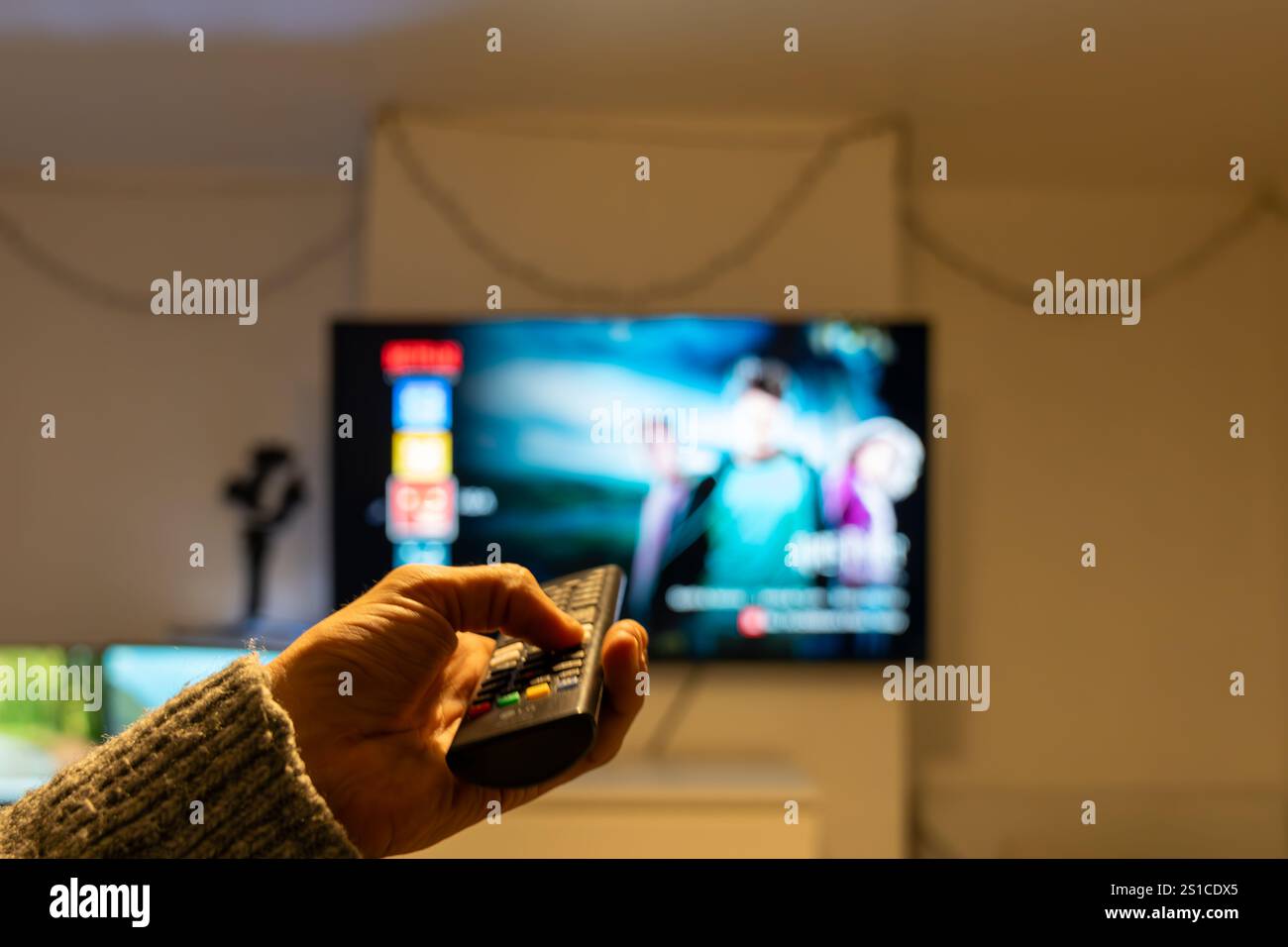 Hand holding remote control and changing channels on a television Stock ...