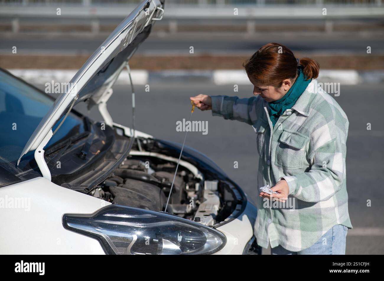 Caucasian female driver checking oil level in car engine Stock Photo - Alamy