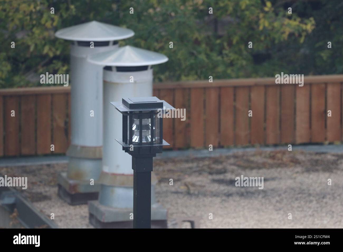 black iron light fixture against two chimneys Stock Photo - Alamy