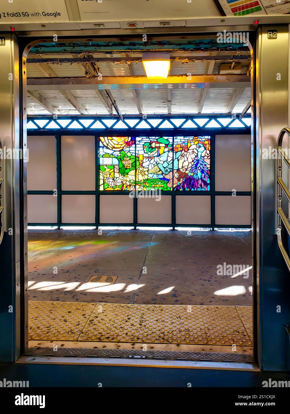 Sunlit stained glass window through open subway doors Stock Photo - Alamy