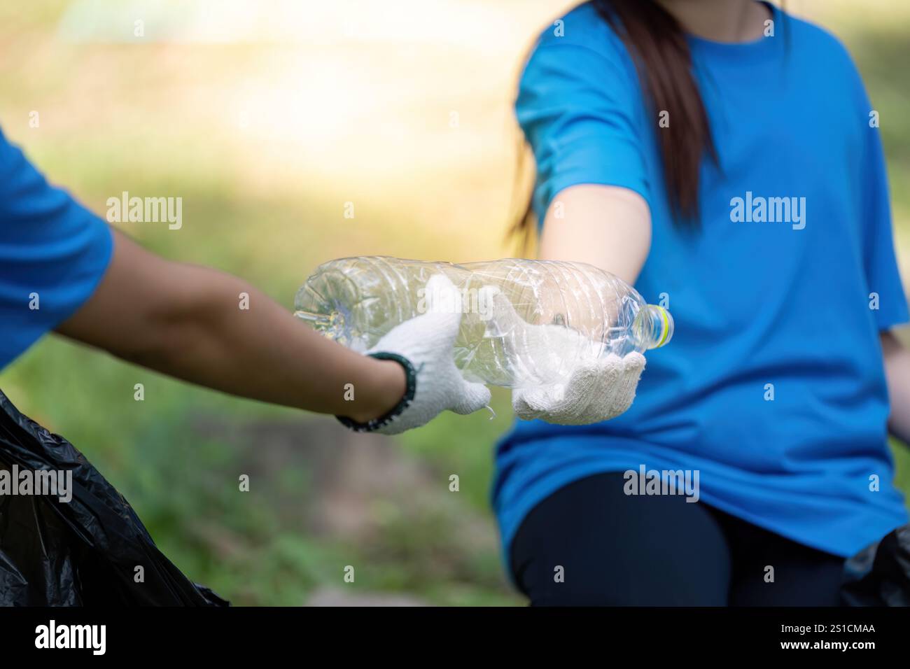 Family volunteers collecting garbage together in nature community event ...