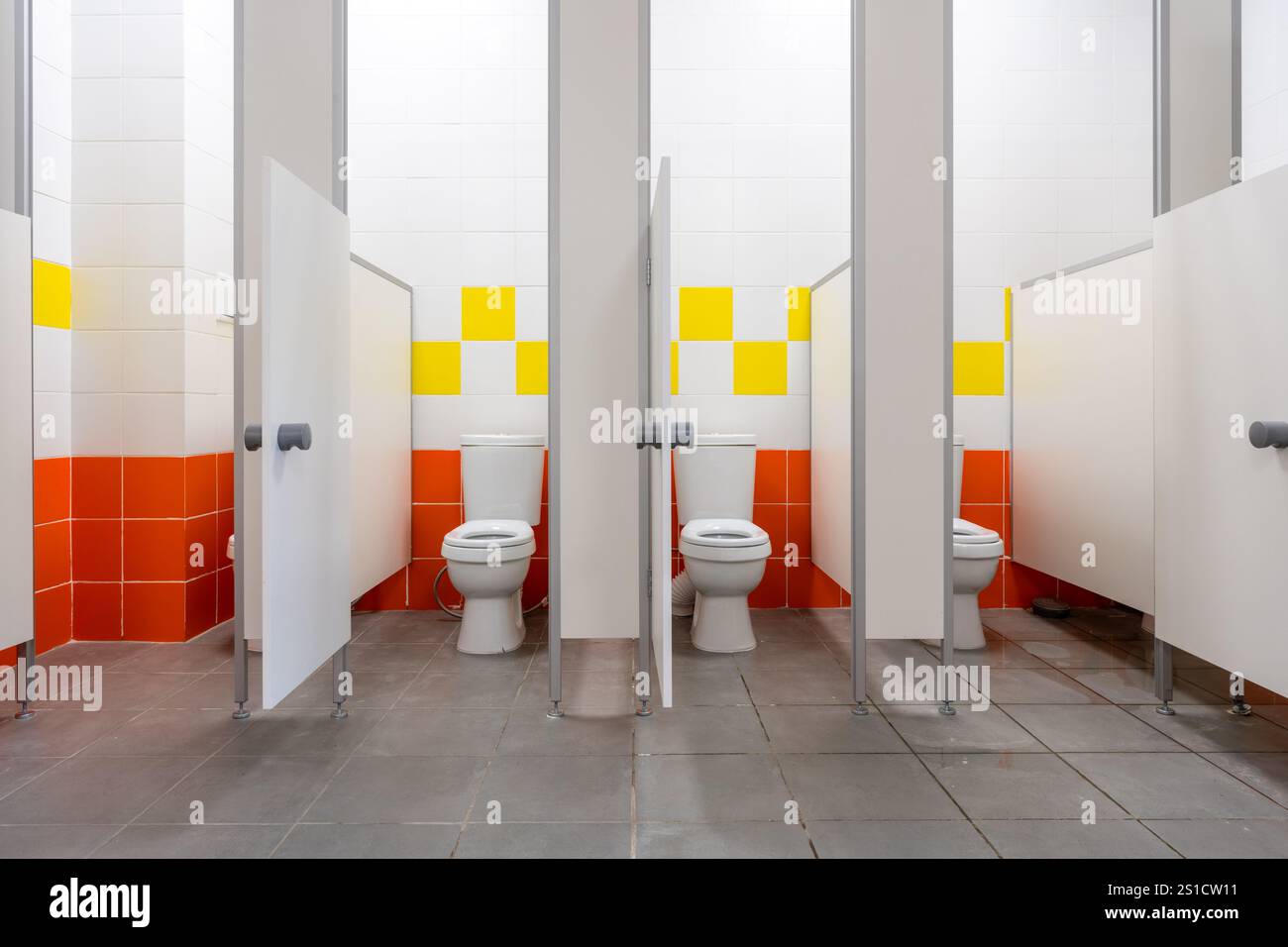 Modern restroom interior featuring clean stalls with vibrant wall tiles ...