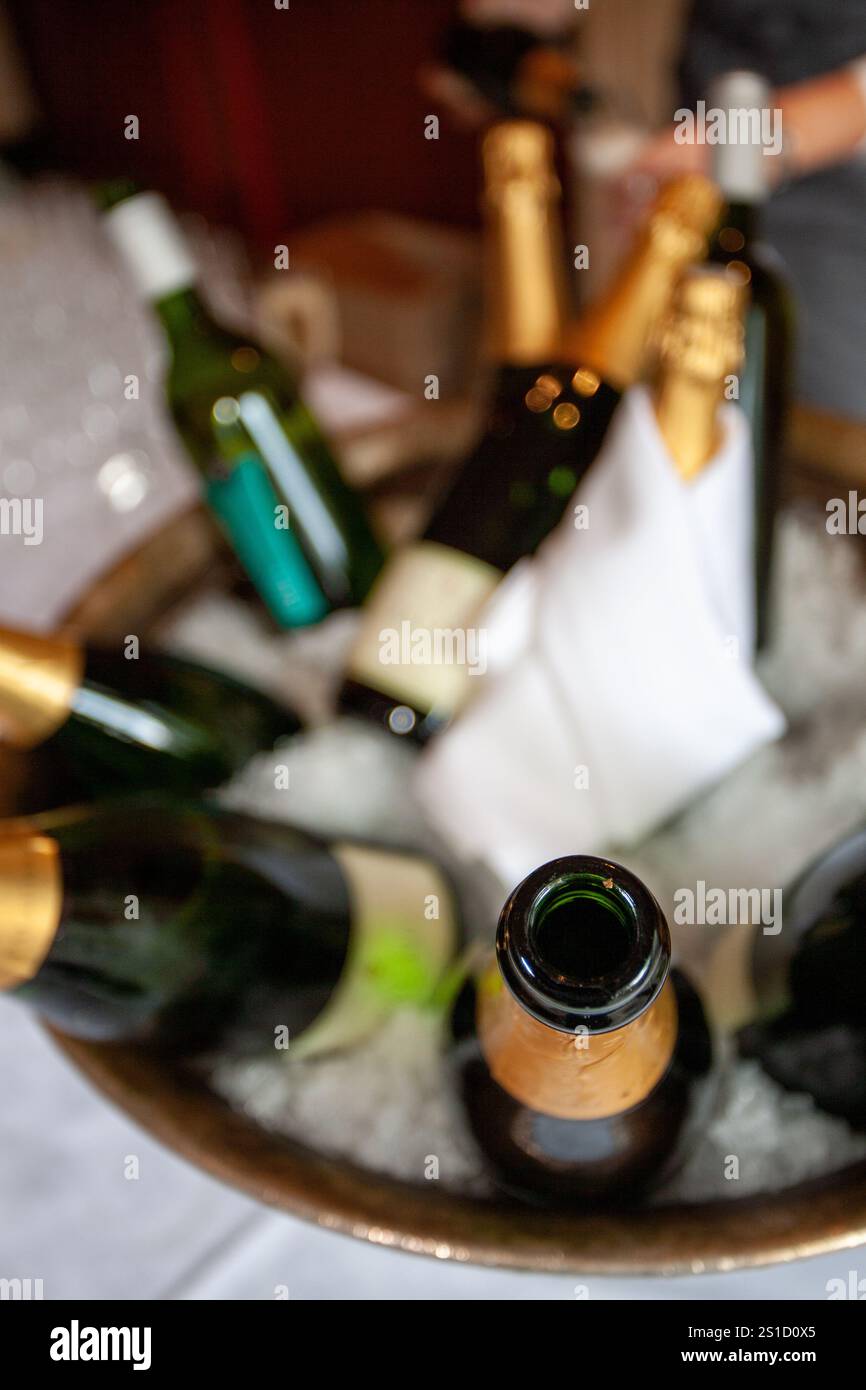 A collection of chilled wine and champagne in an icefilled bucket ...