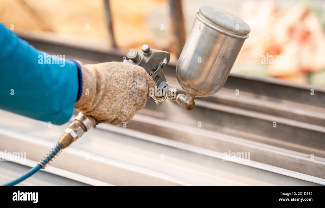 Construction worker painting metal structure surface coating with a ...
