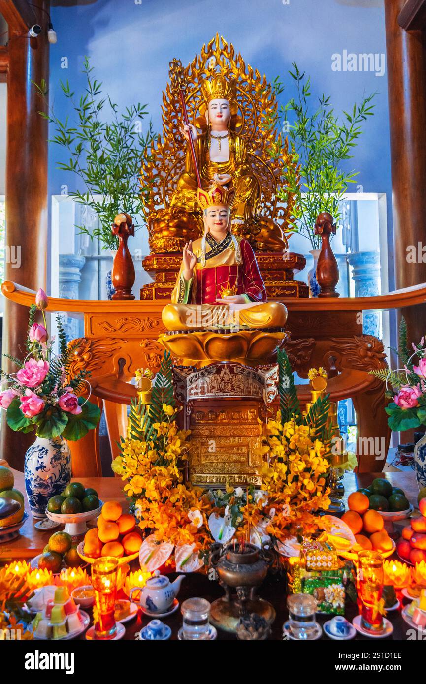 figurine of golden Shiva and white Buddha on an altar decorated with ...