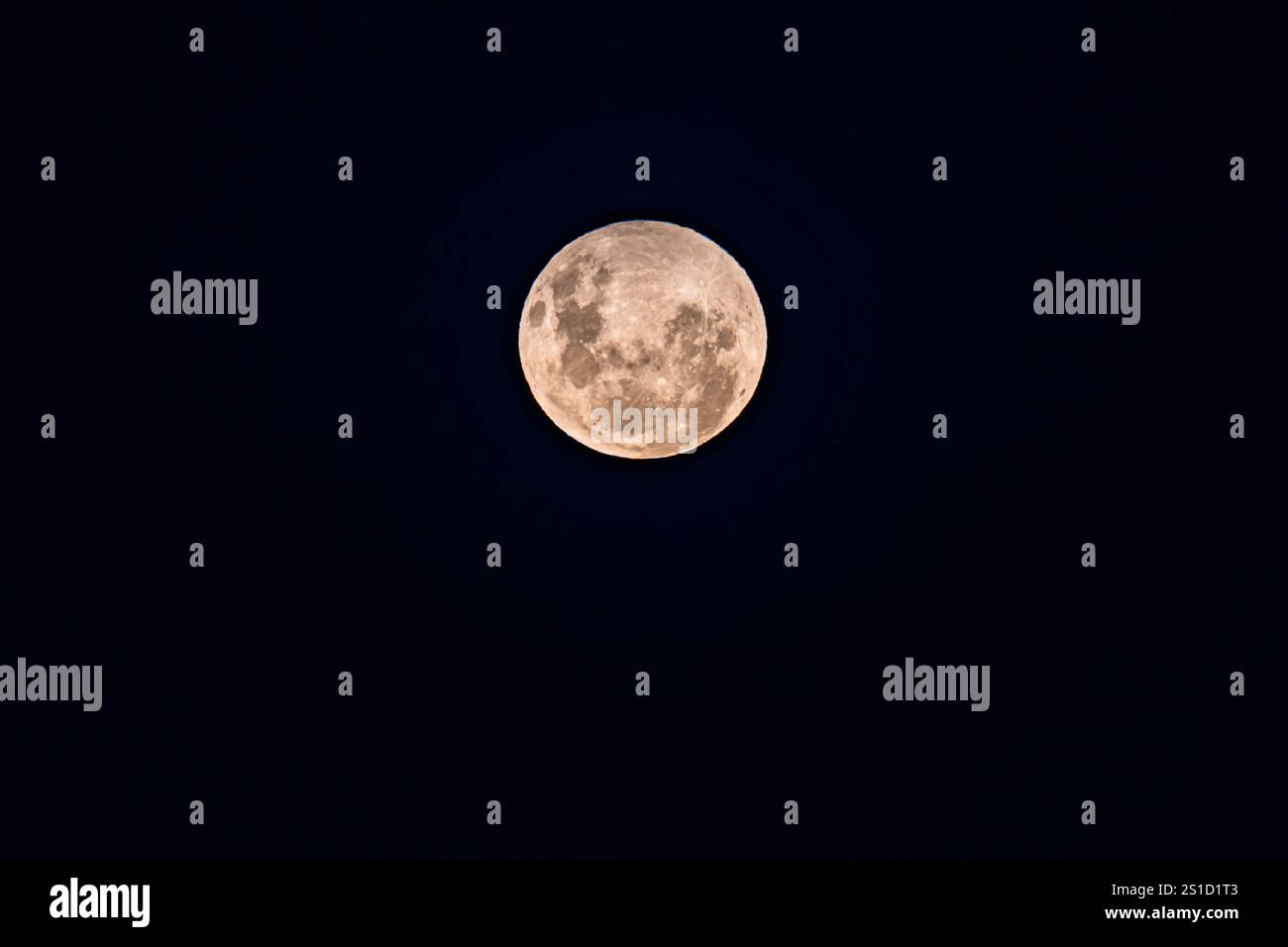 Full Moon Worm Moon rising in the clear night sky as a penumbral lunar ...
