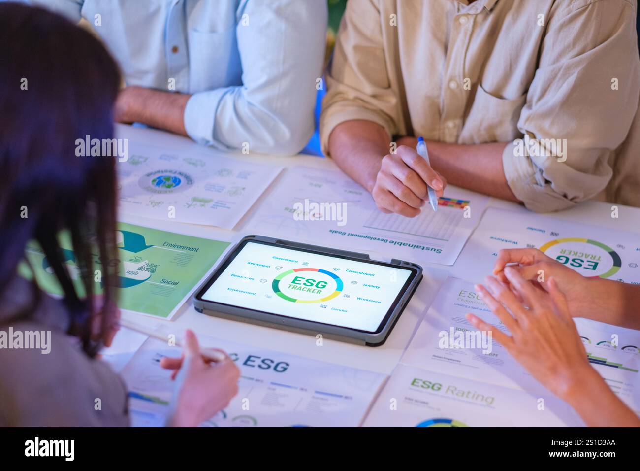 diversity team brainstorming focused on ESG (environment,social,governance) with tablet or sdgs ...