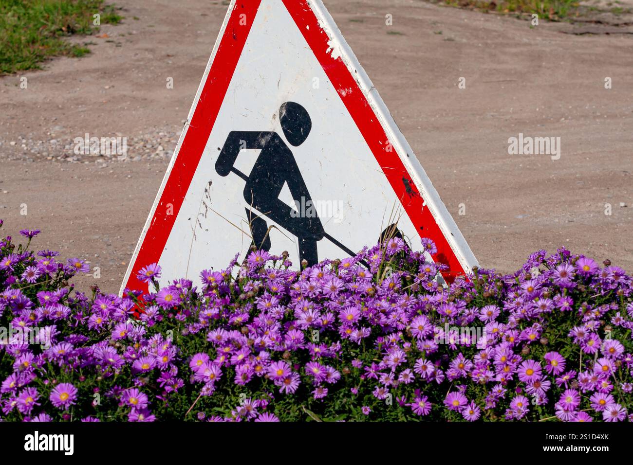 A triangular traffic sign indicating roadwork is decorated with vibrant ...