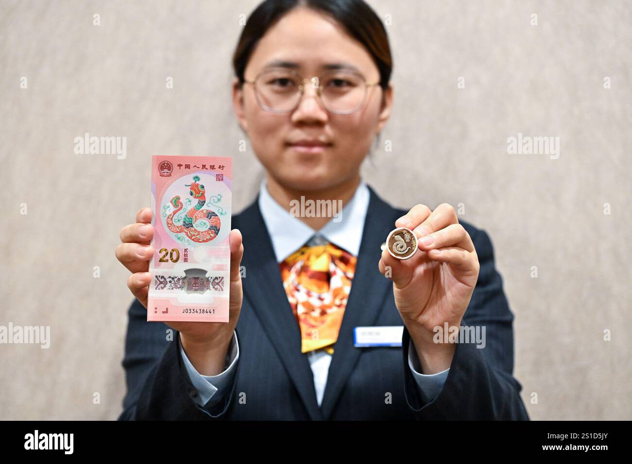 Beijing, China. 3rd Jan, 2025. A staff member shows commemorative coins ...