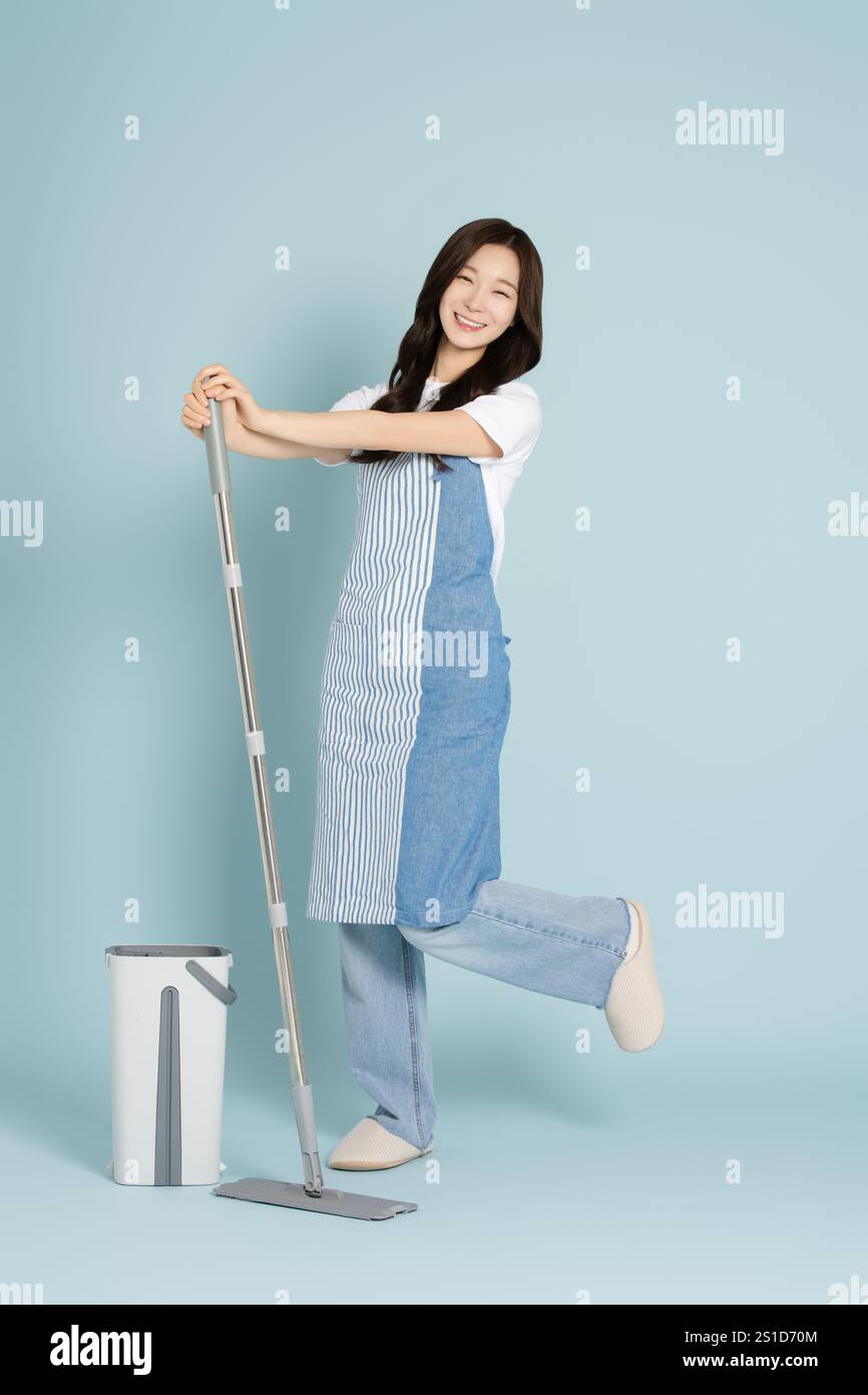 A woman in her 20s mopping the floor with a gunny mop Stock Photo - Alamy