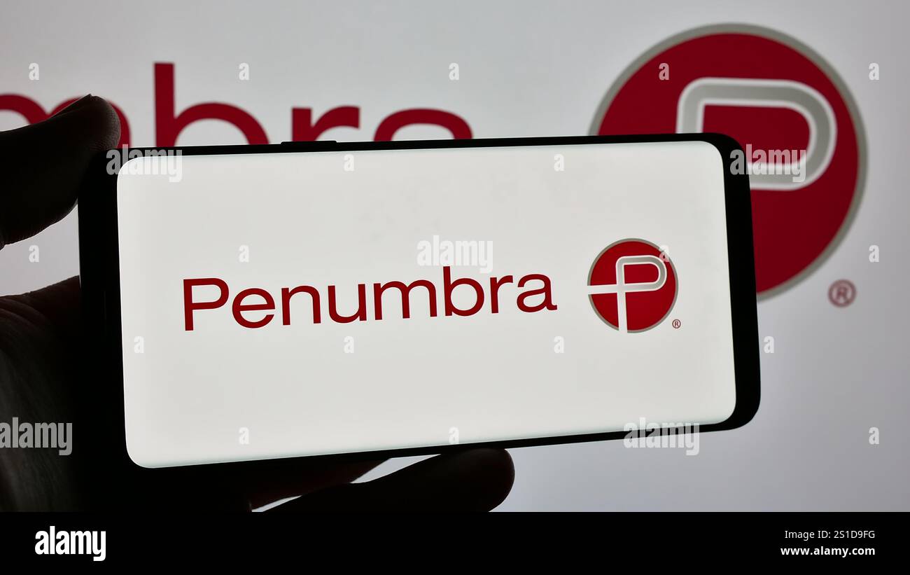 In this photo illustration, a person is holding a smartphone with the logo of US medical device ...