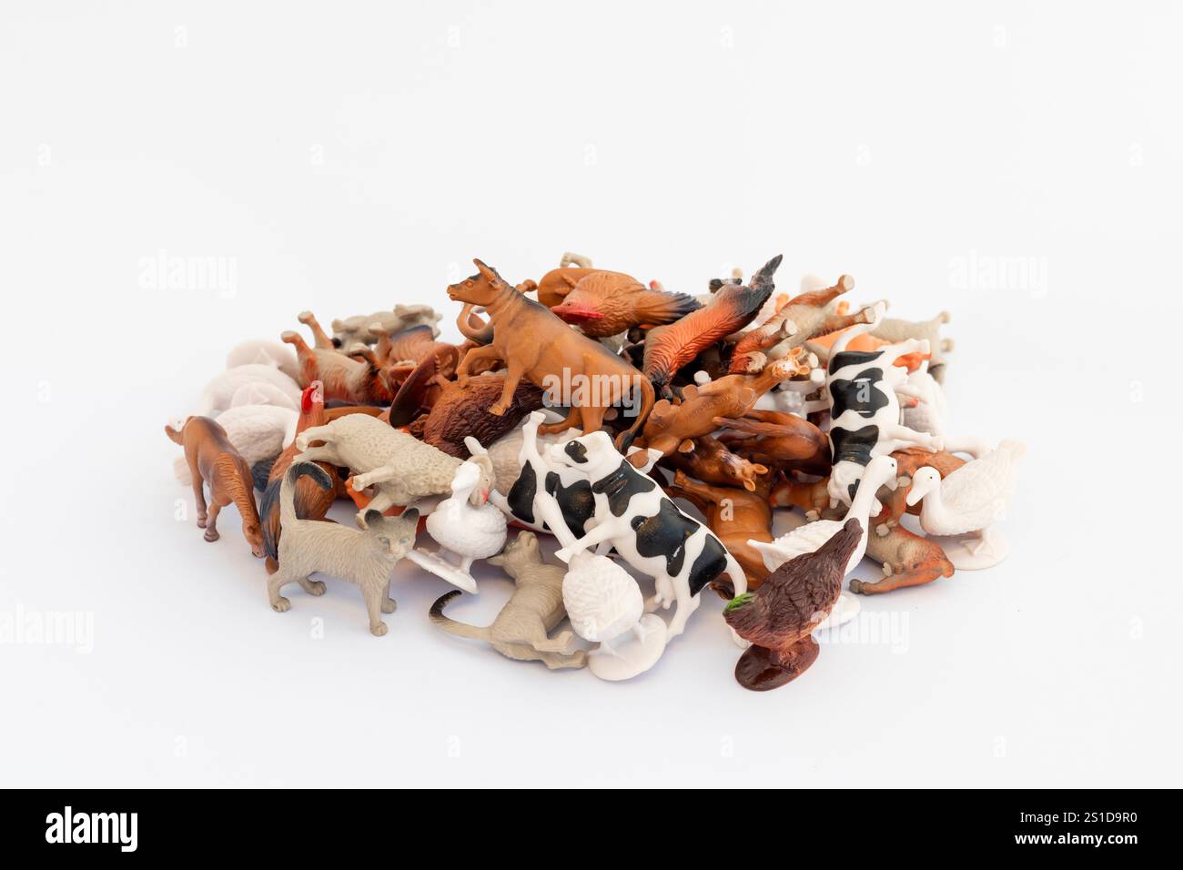 Pile of toy miniature mixed farm animals on white isolated background ...