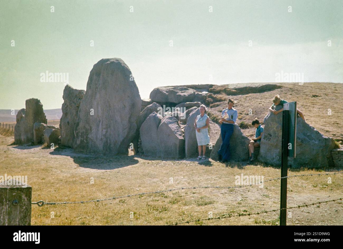 Family in front of long barrow burial chamber, West KennetWiltshire ...
