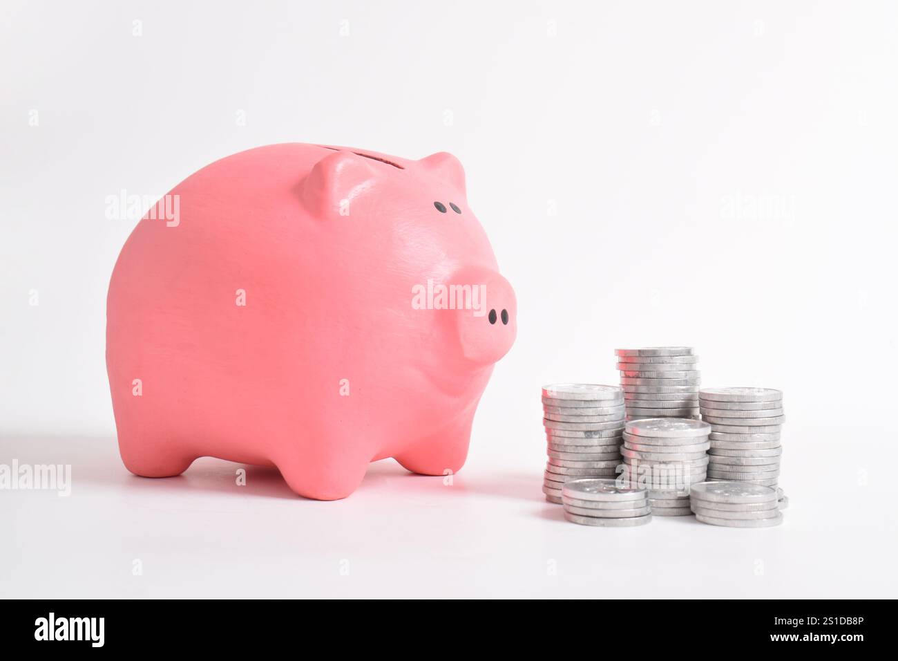 Pink piggy bank and stack of coins isolated on white background ...