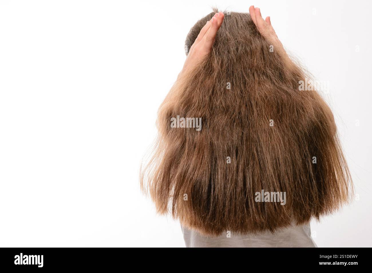 A person with very long, light brown hair is seen from behind, their ...