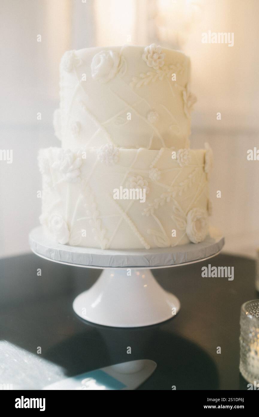 two tier white wedding cake with floral detail Stock Photo - Alamy
