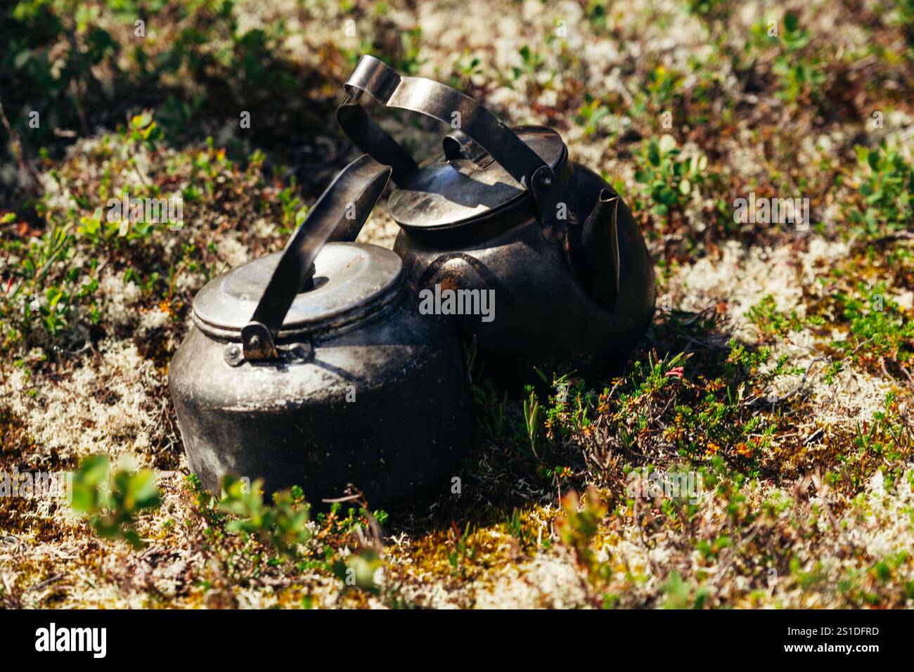 Two Worn Coffee Kettles on Ground Stock Photo - Alamy