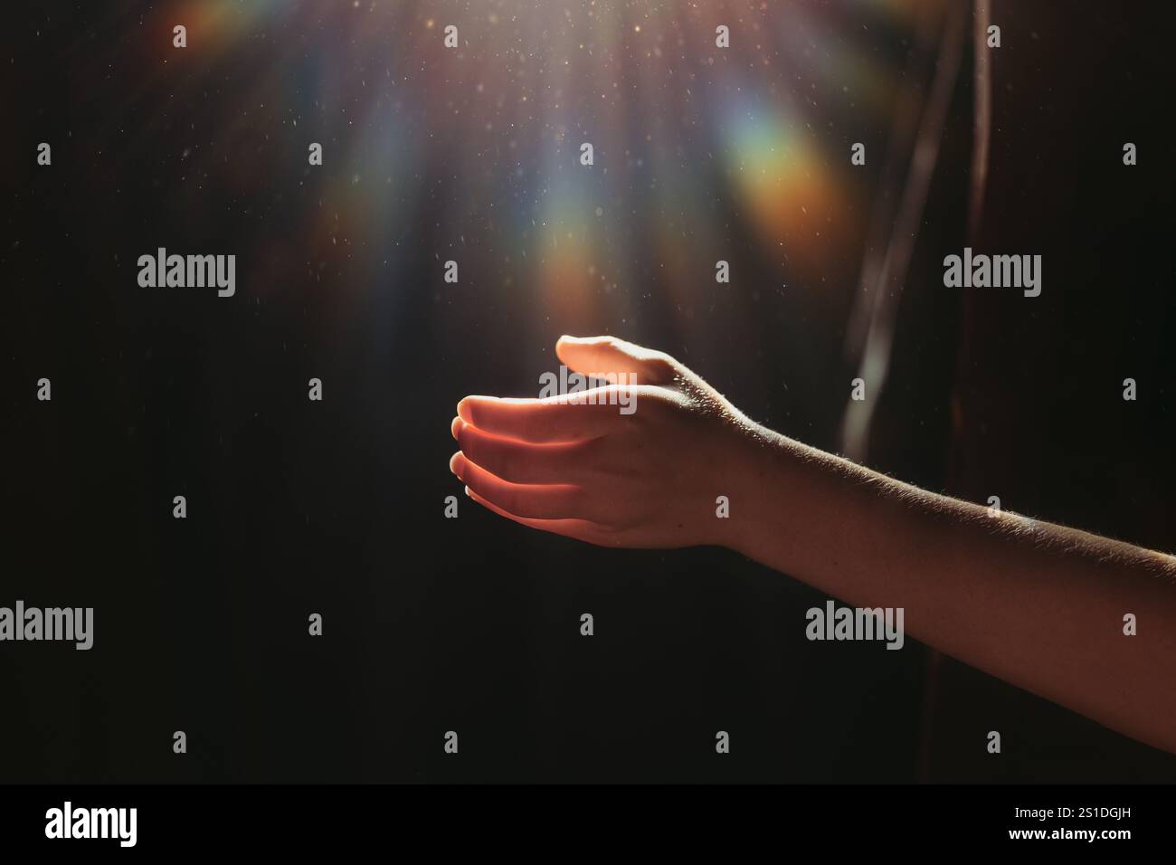 Hand reaching for Sunlight with rainbow flare Stock Photo - Alamy
