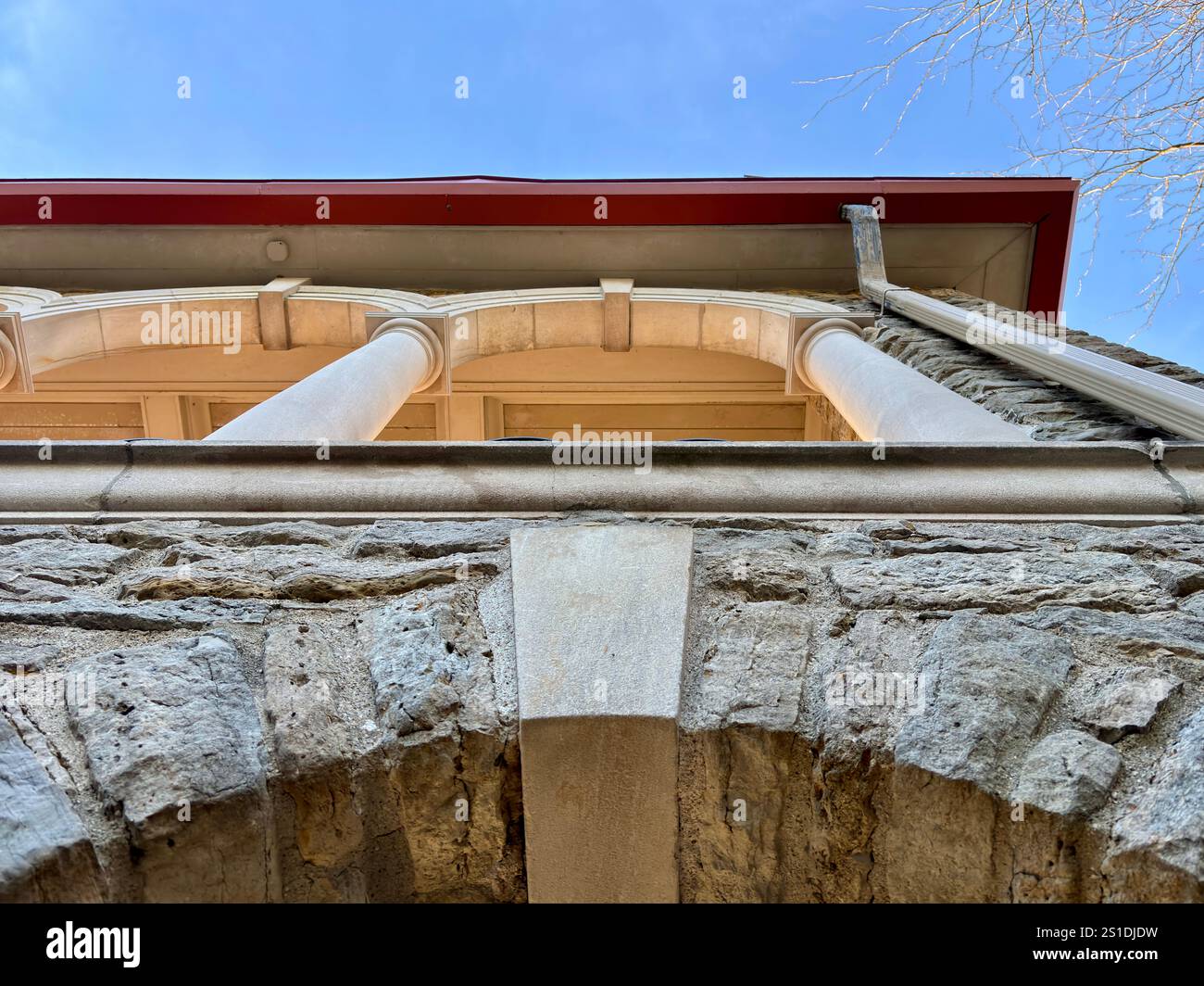 Closeup of a stone arch and columns under a red roof Stock Photo - Alamy