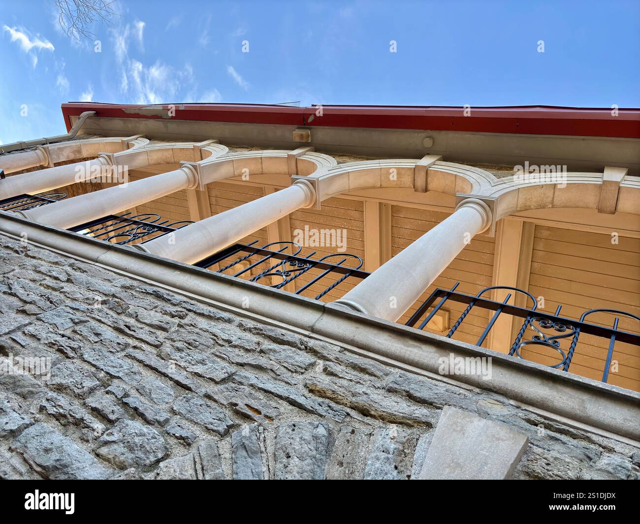 Upward view of stone arches and columns under red roof Stock Photo - Alamy