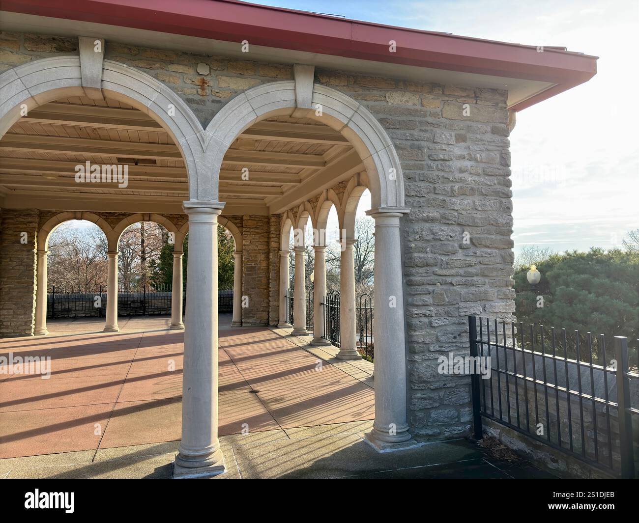 Stone pavilion with arched columns, casting shadows in soft sunlight ...