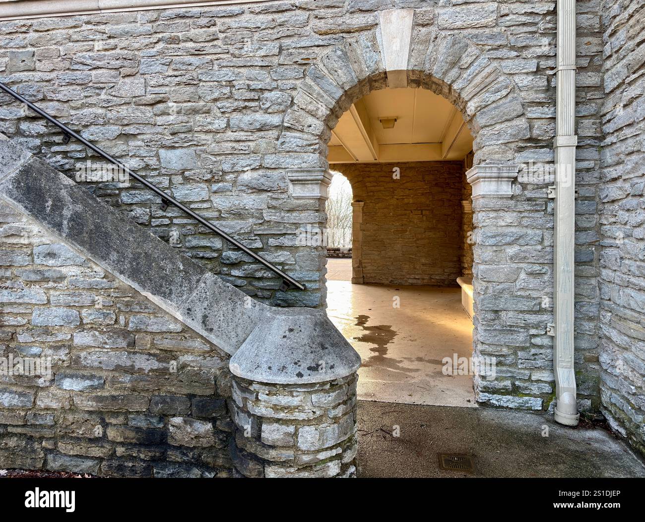 Stone staircase with handrail, arched passageway bathed in soft light ...