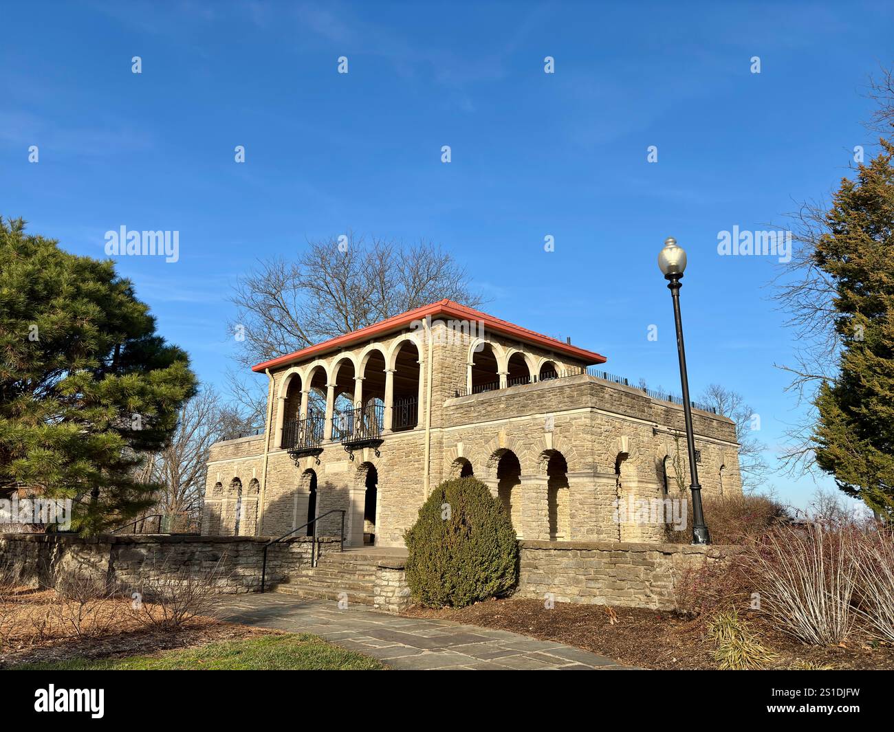 Historic stone pavilion with arches, a red roof, and clear blue skies ...