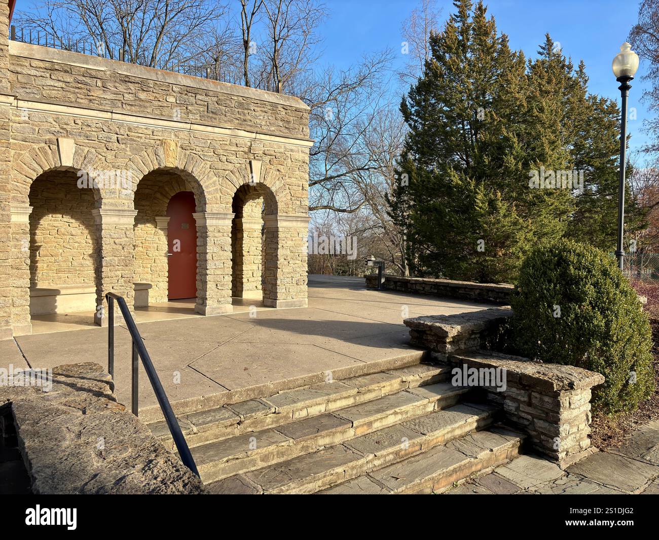 Stone building exterior with arches, steps, surrounding greenery Stock ...