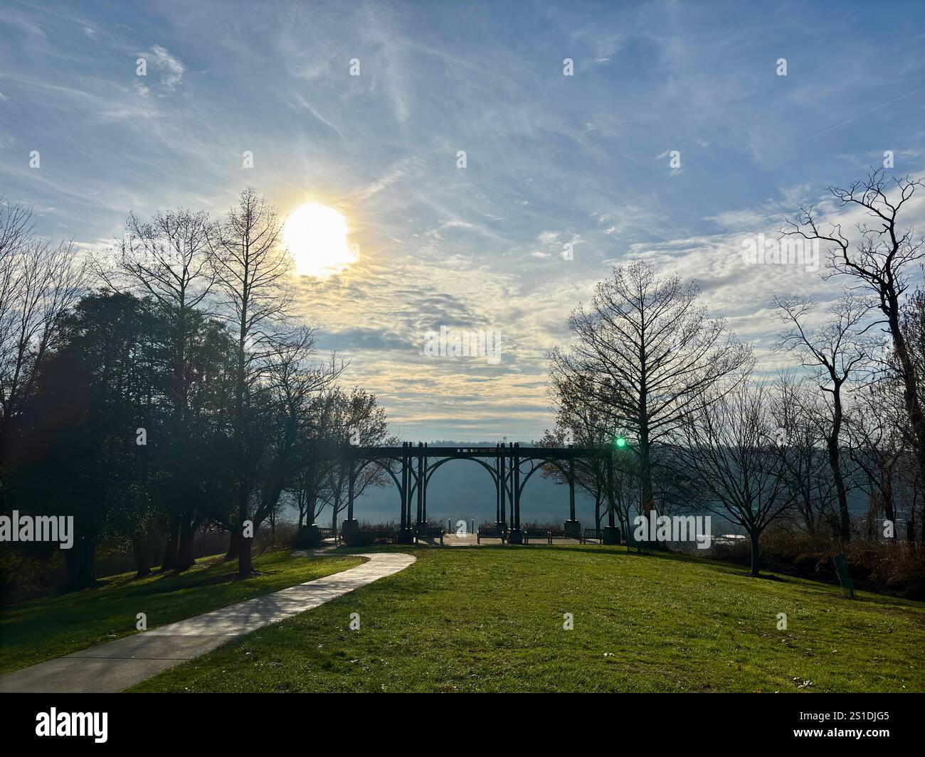 Scenic park with pathway, trees, overlook, cloudy sky with sun Stock ...