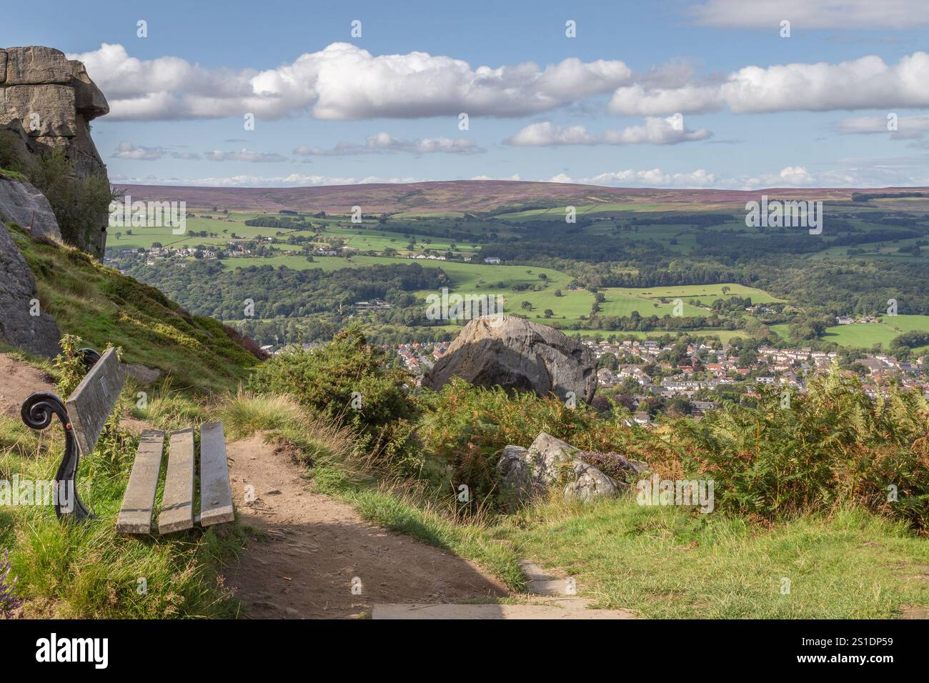 A wooden seat next to the Cow and Calf rocks on Ilkley Moor with long ...