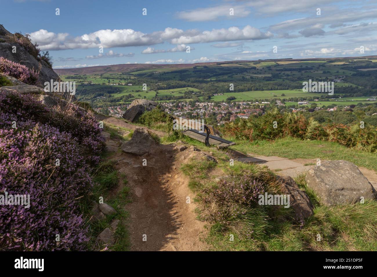 A wooden seat next to the Cow and Calf rocks on Ilkley Moor with long ...
