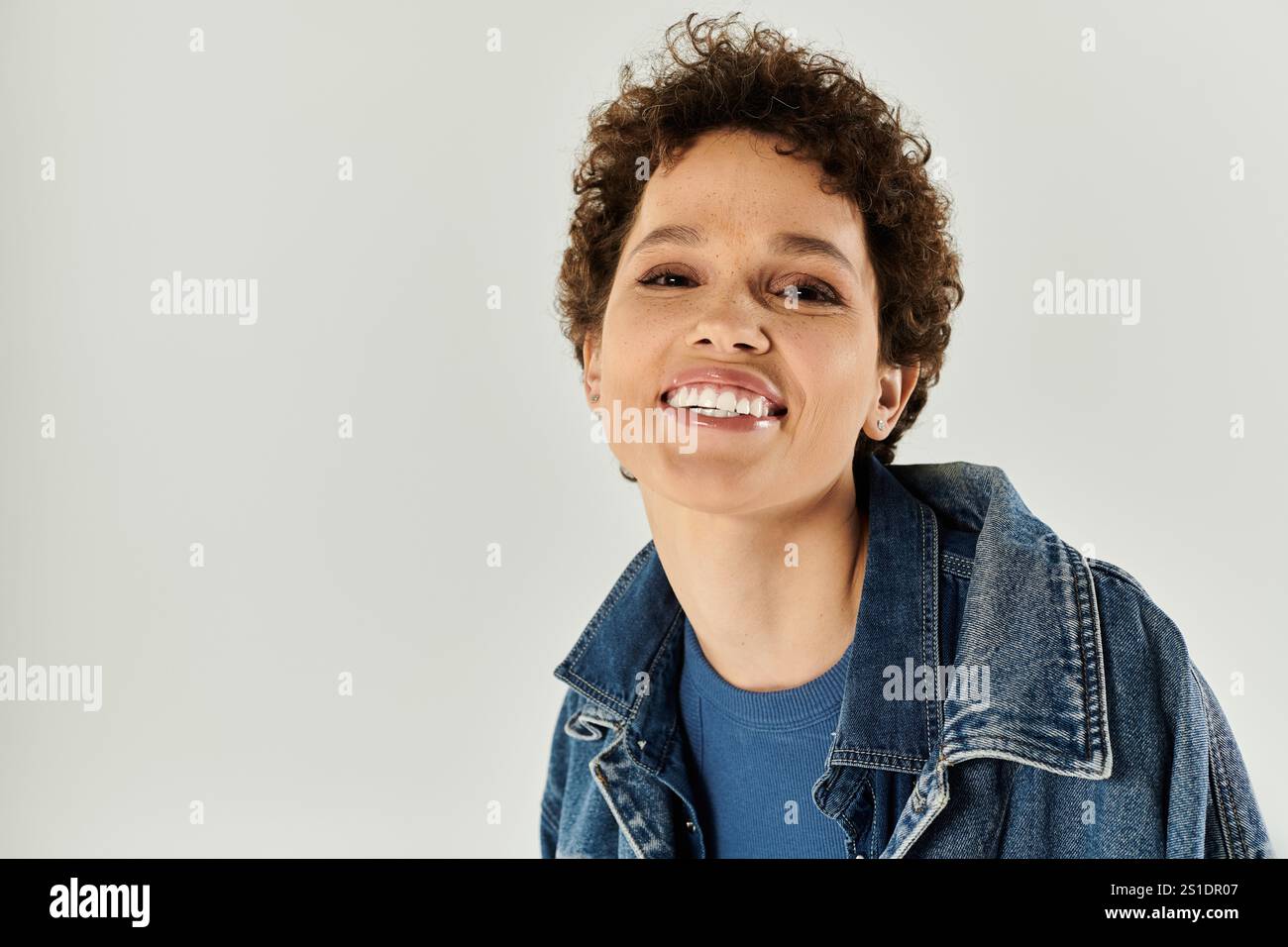 A beautiful young woman shares her radiant smile in a stylish denim ...