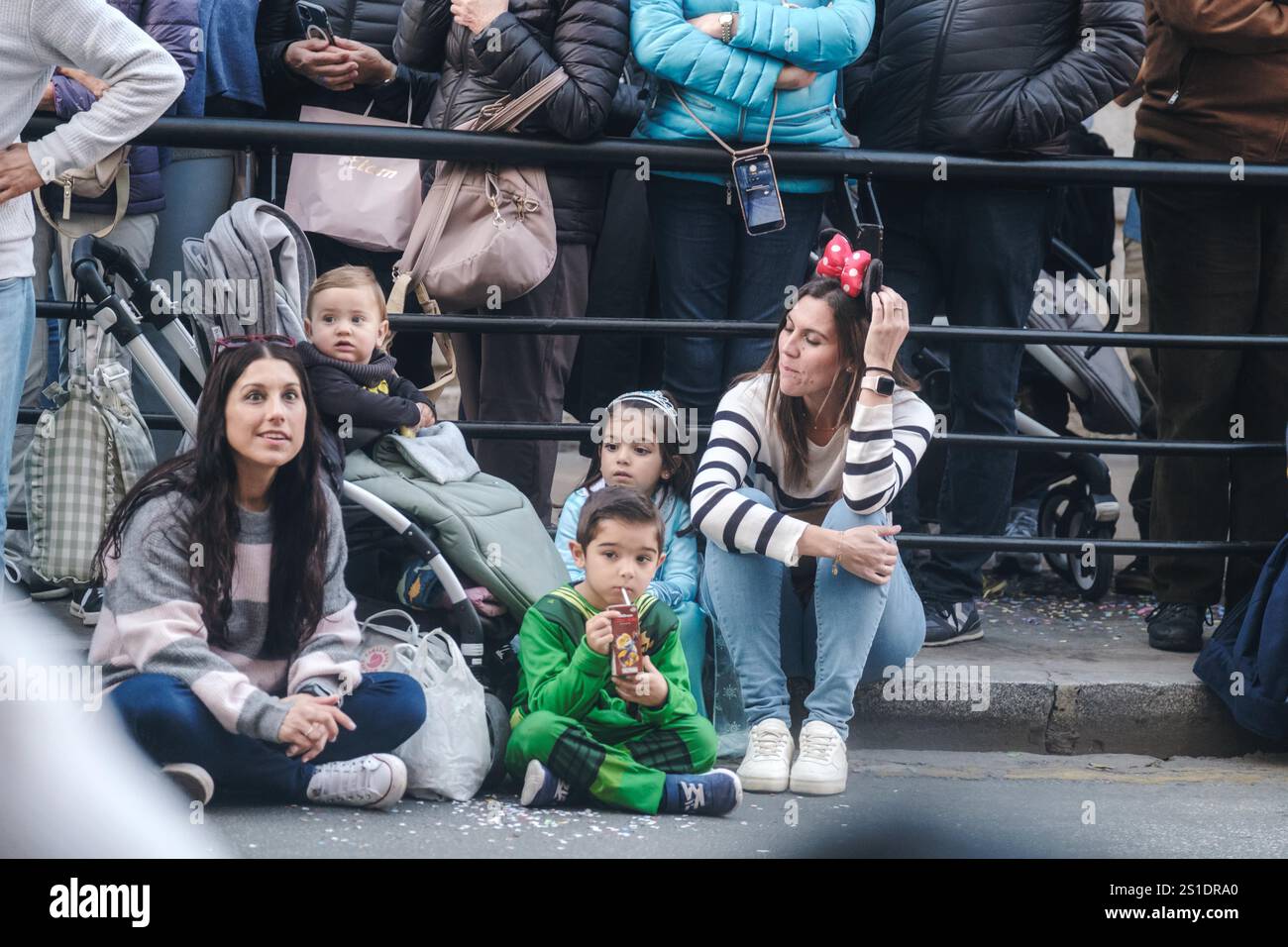 Family-friendly event spectators: Two mothers and three kids, one in a ...