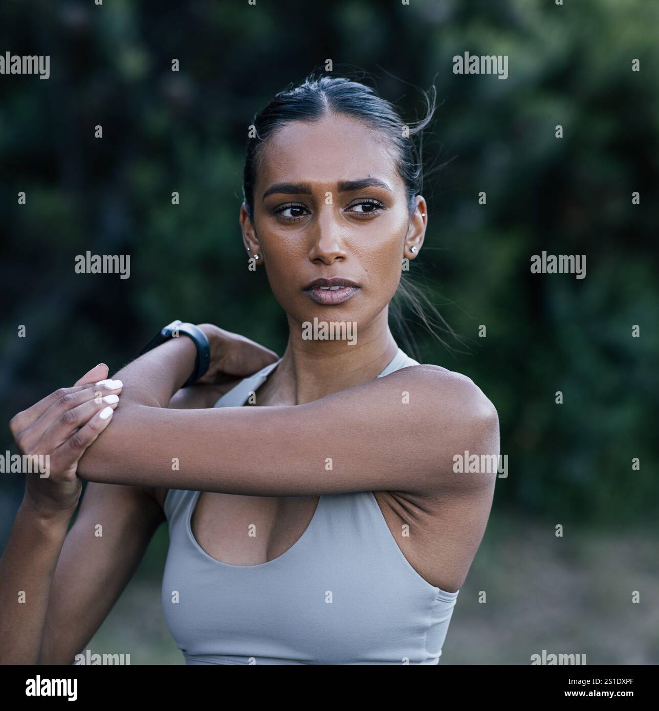 Portrait of young slim athlete warming up upper body while standing outdoors Stock Photo - Alamy