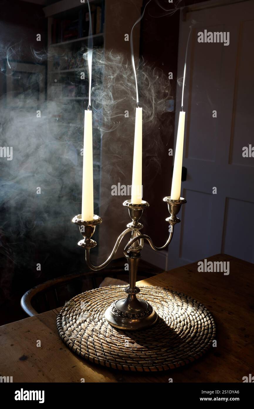Smoking Candles against sun light in a three arm candelabra. UK Stock ...