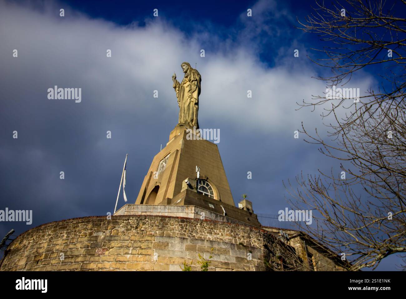 Close-up view of the Cristo de la Mota statue atop Monte Urgull with dramatic sky in San ...