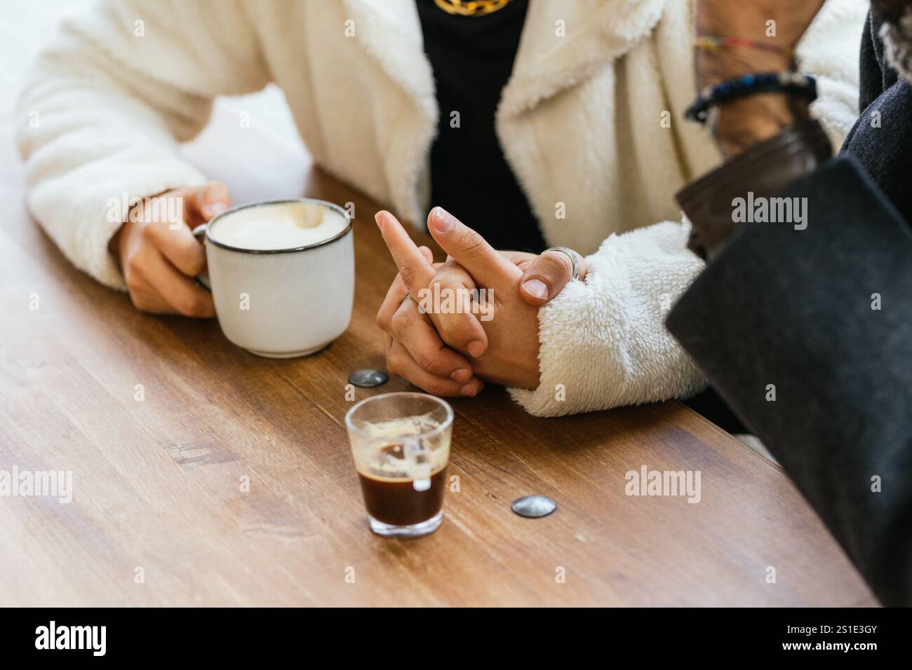 Gay couple holding hands and drinking coffee at cafe Stock Photo - Alamy