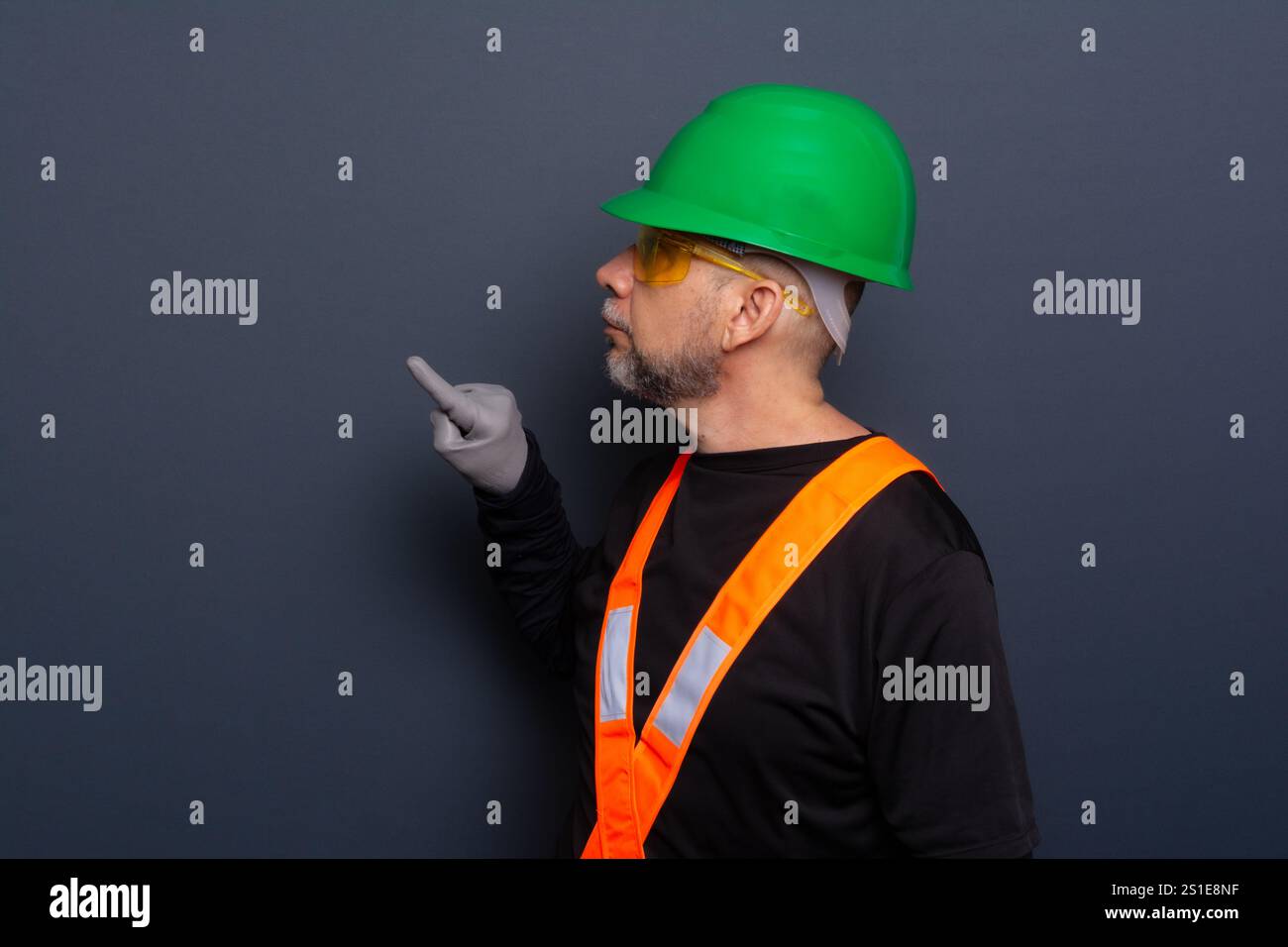 A civil worker wearing green helmet, reflective vest and protective ...