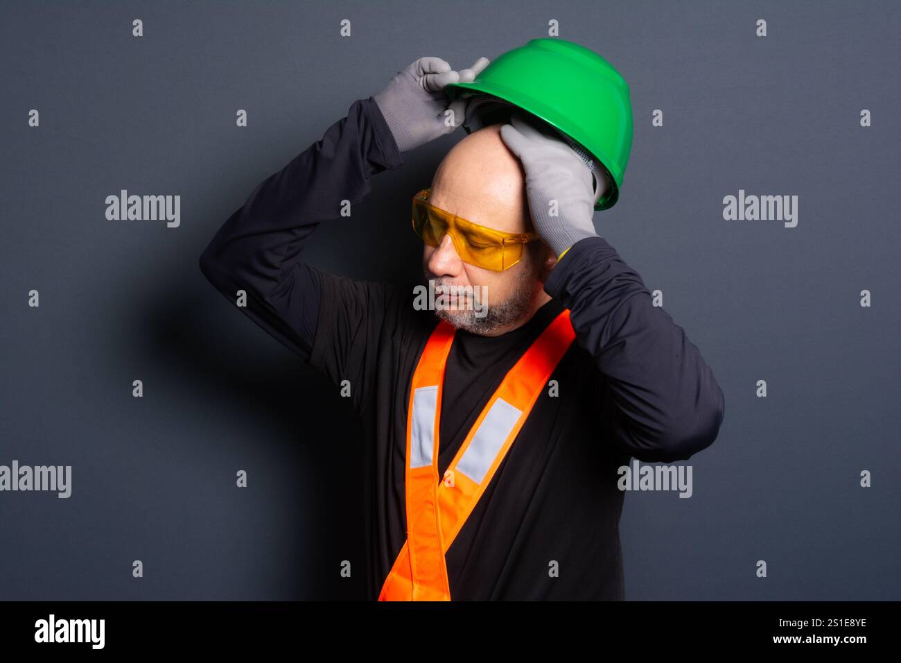 Photo of a civil worker wearing a green hard hat, reflective vest and ...