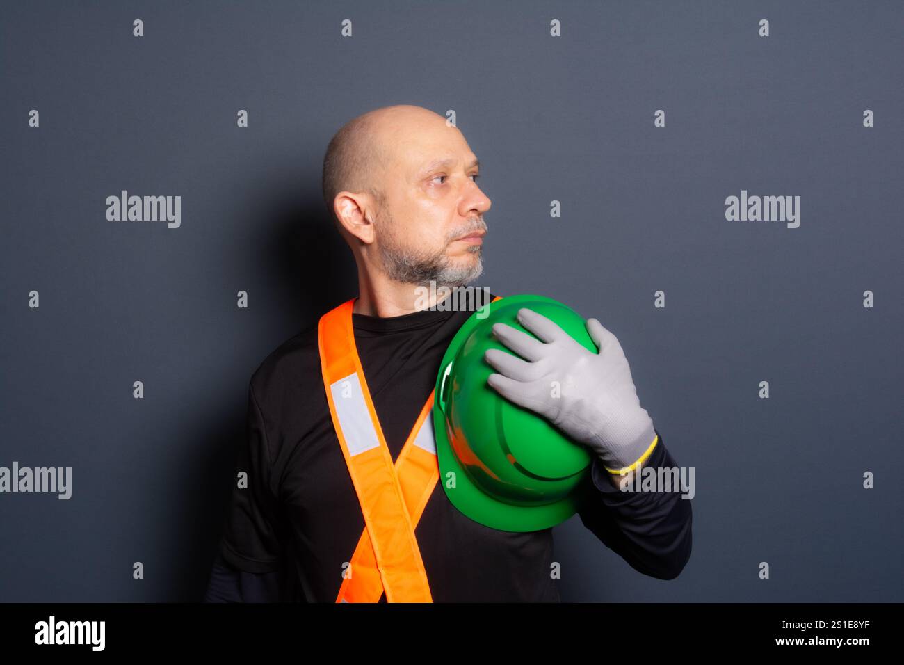 Photo of a civil worker in gloves and reflective vest holding green ...
