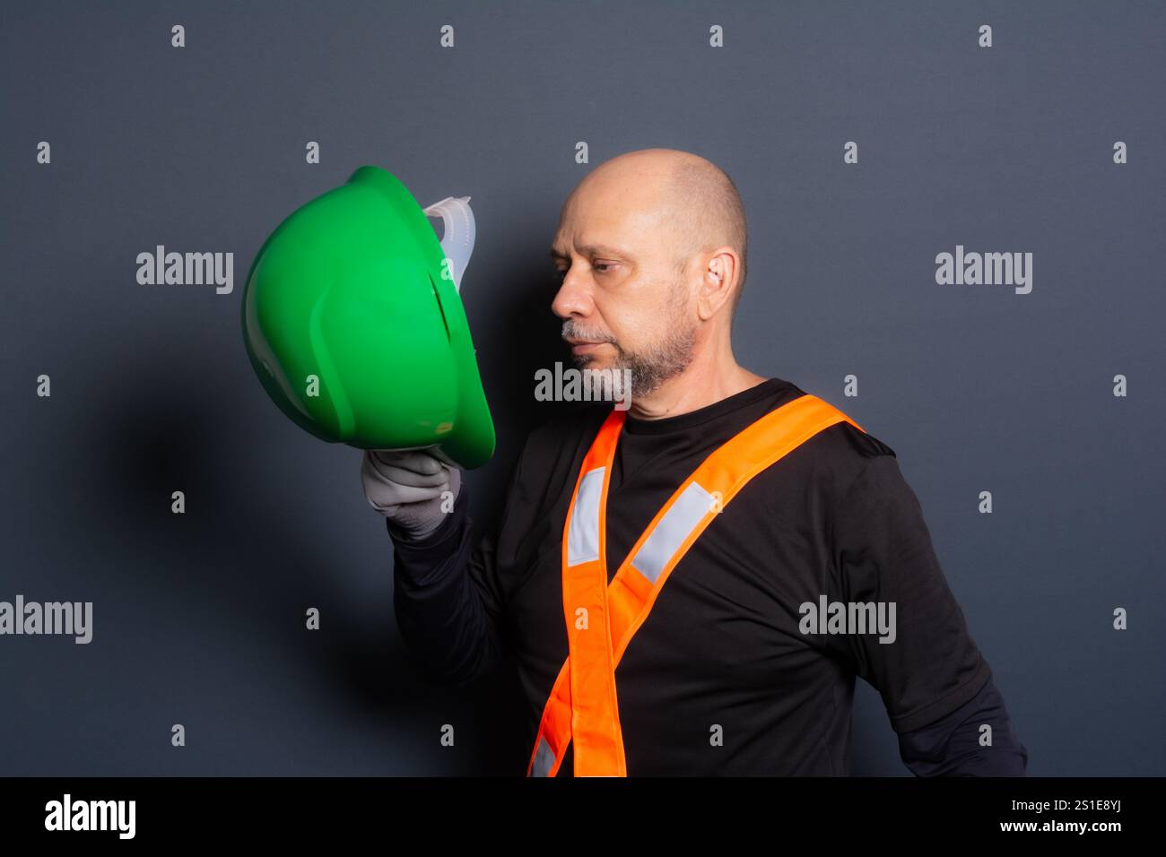 Photo of a civil worker in gloves and reflective vest holding green ...