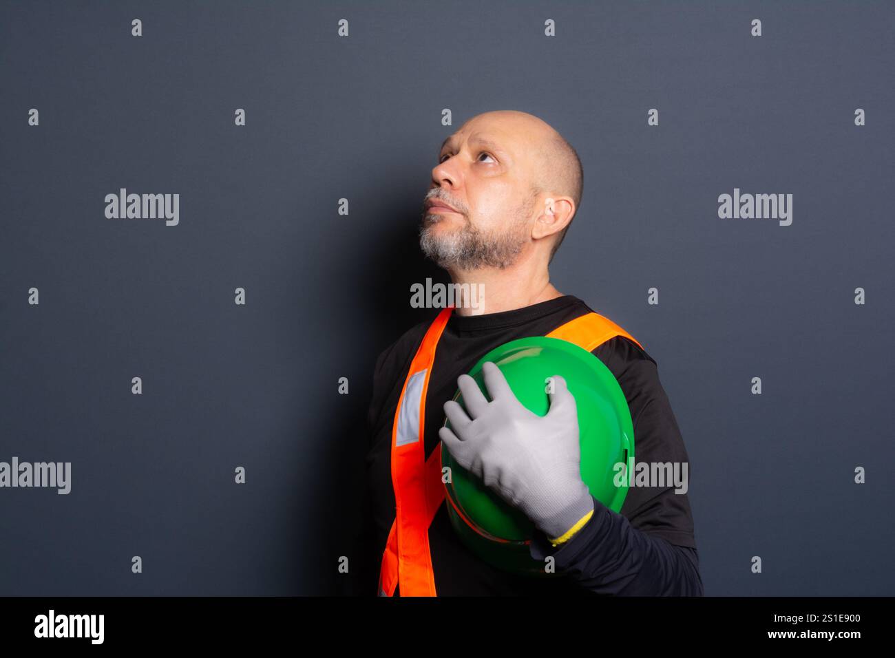 Photo of a civil worker in gloves and reflective vest holding green ...