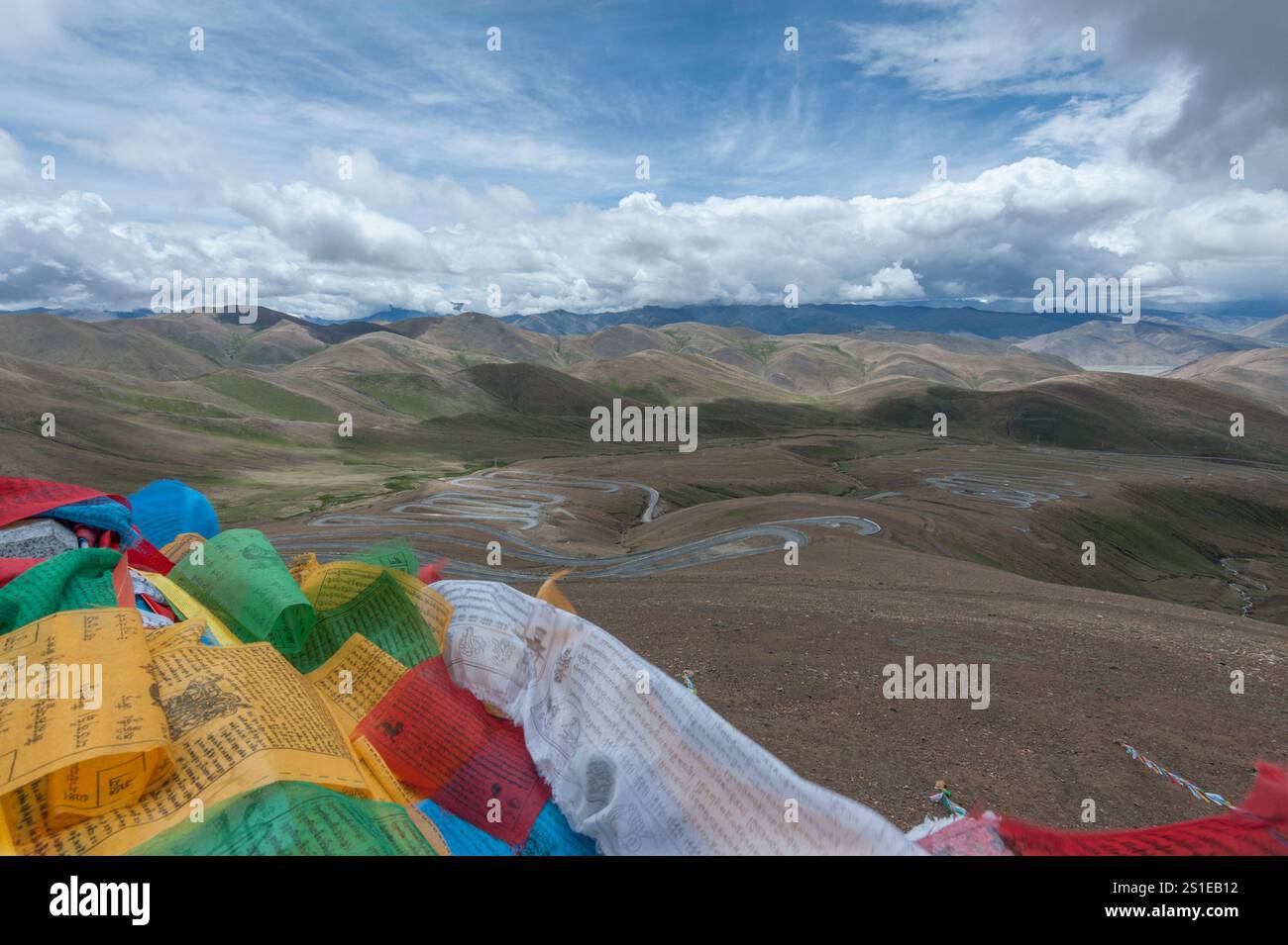Colorful prayer flags flutter above serpentine road across Pang La Pass ...