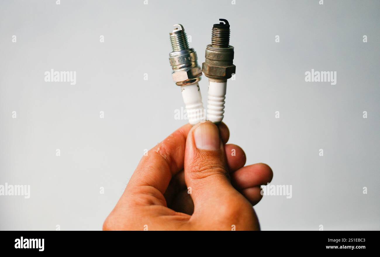 Close up of hand holding old and new spark plugs engine Stock Photo - Alamy