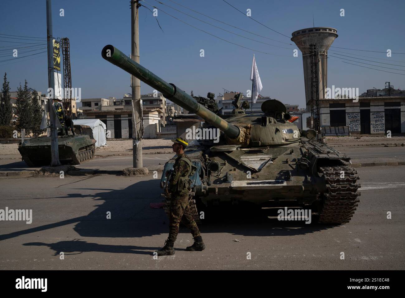 A member of the new security forces walks past tanks during an ...