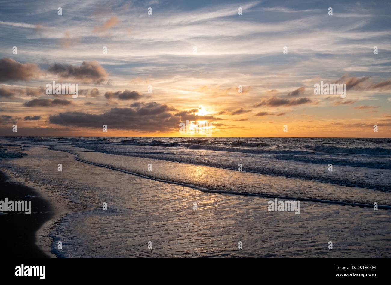 A stunningly beautiful sunset glows and reflects on the ocean waves ...