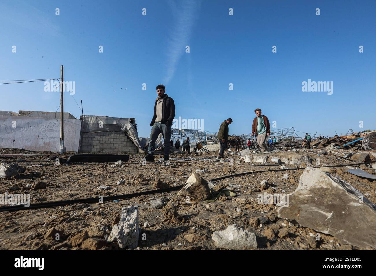 Palestinian inspect the rubbles of a factory destroyed by Israeli air ...