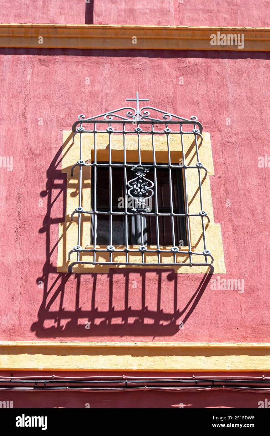 Window protected with grille, facade in pipeclay (albero) and crimson ...