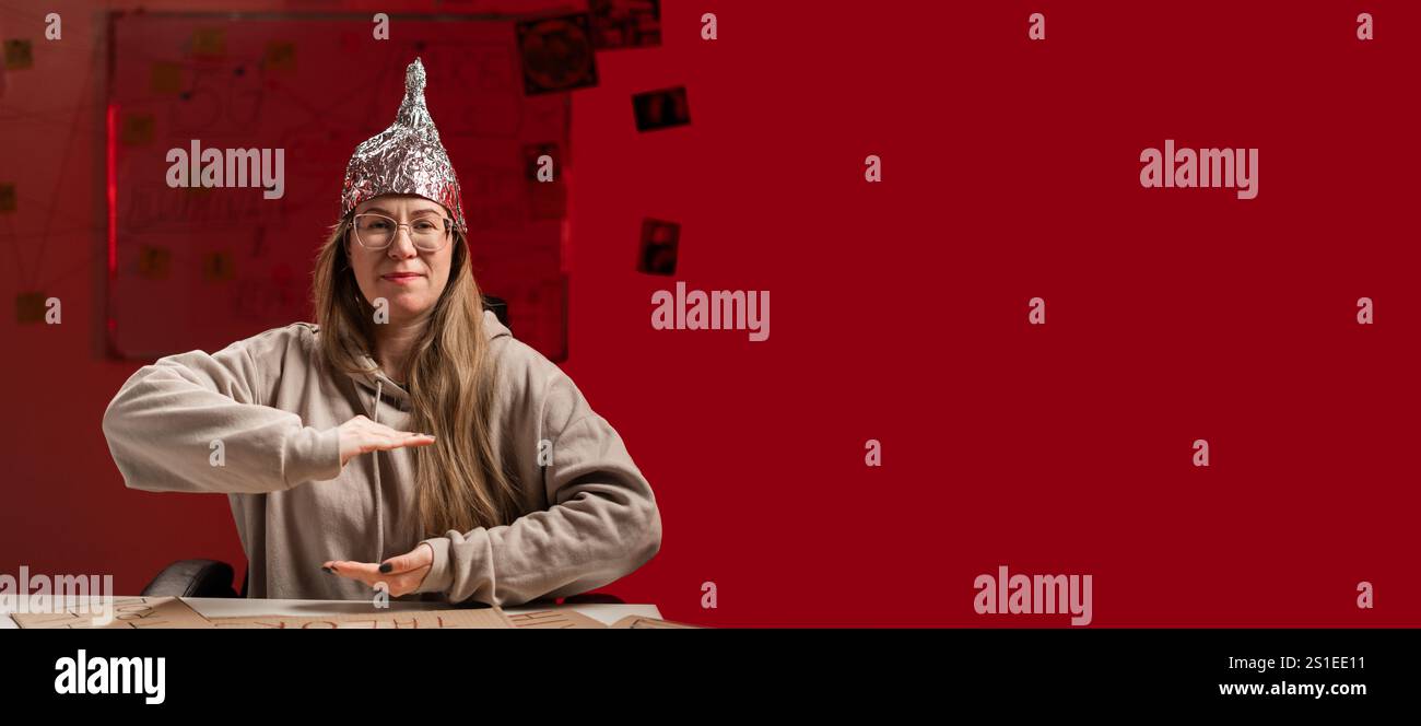 Woman wearing glasses in foil hat showing big size sign with hands ...