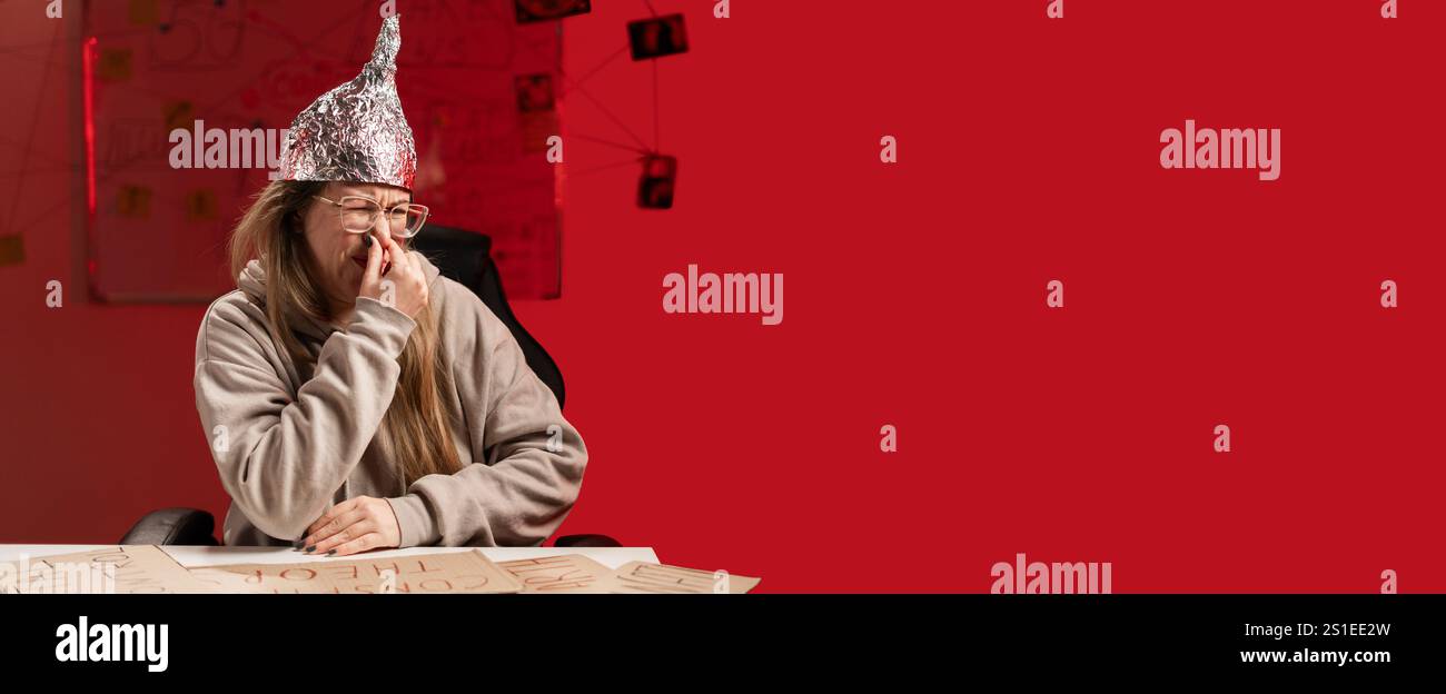 Female conspiracy theorist in protective foil cap and glasses debunks ...